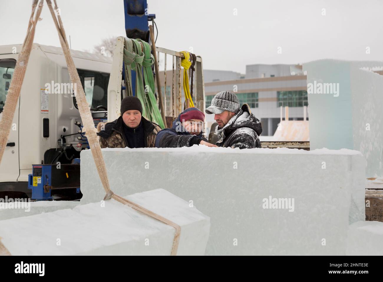 Installers at the construction site of the ice camp discuss a plan for ...