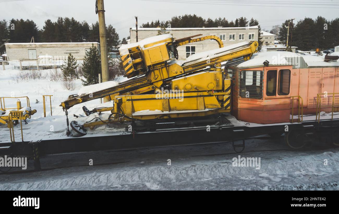 Construction train with yellow machine with locomotive. winter weather ...