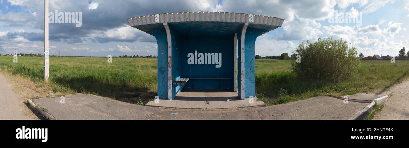 Rural bus stop on the country road with the field on the background ...