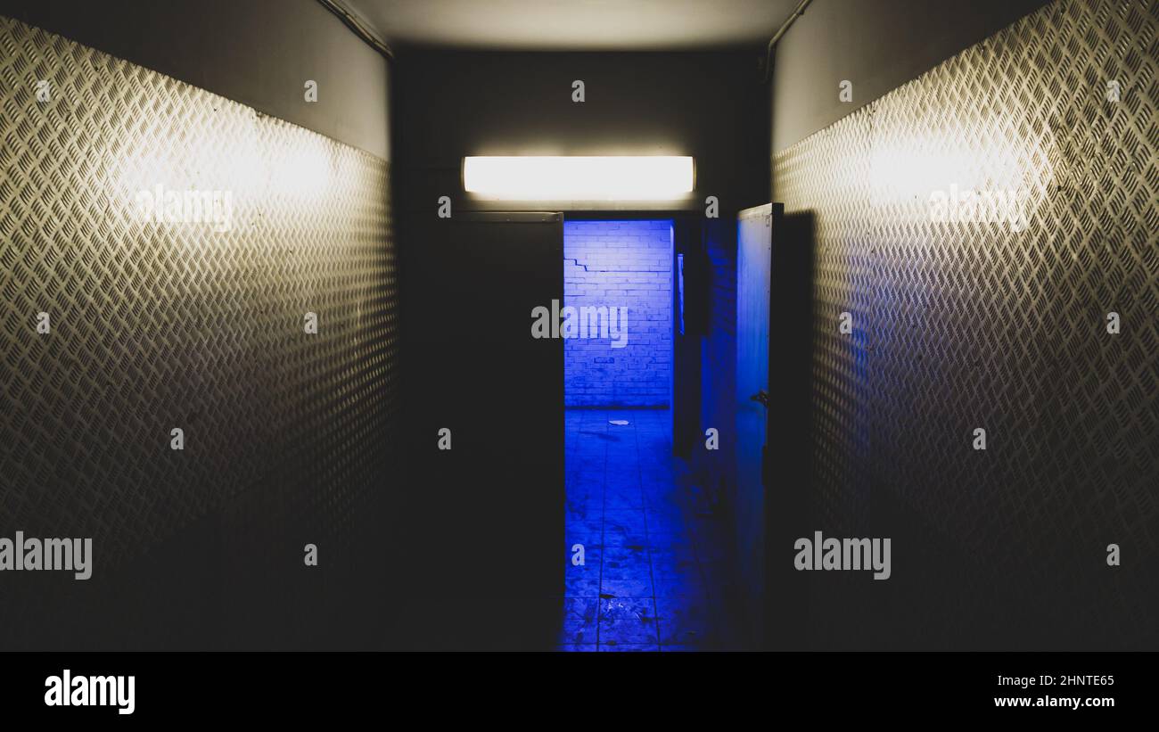 Blue light behind an open door in a mysterious corridor. secret exit ...