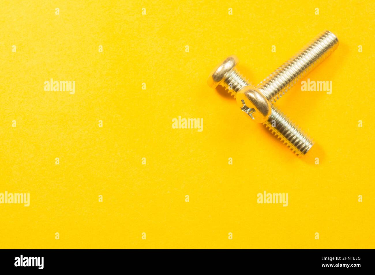 Steel screw on a yellow background. working tools Stock Photo - Alamy