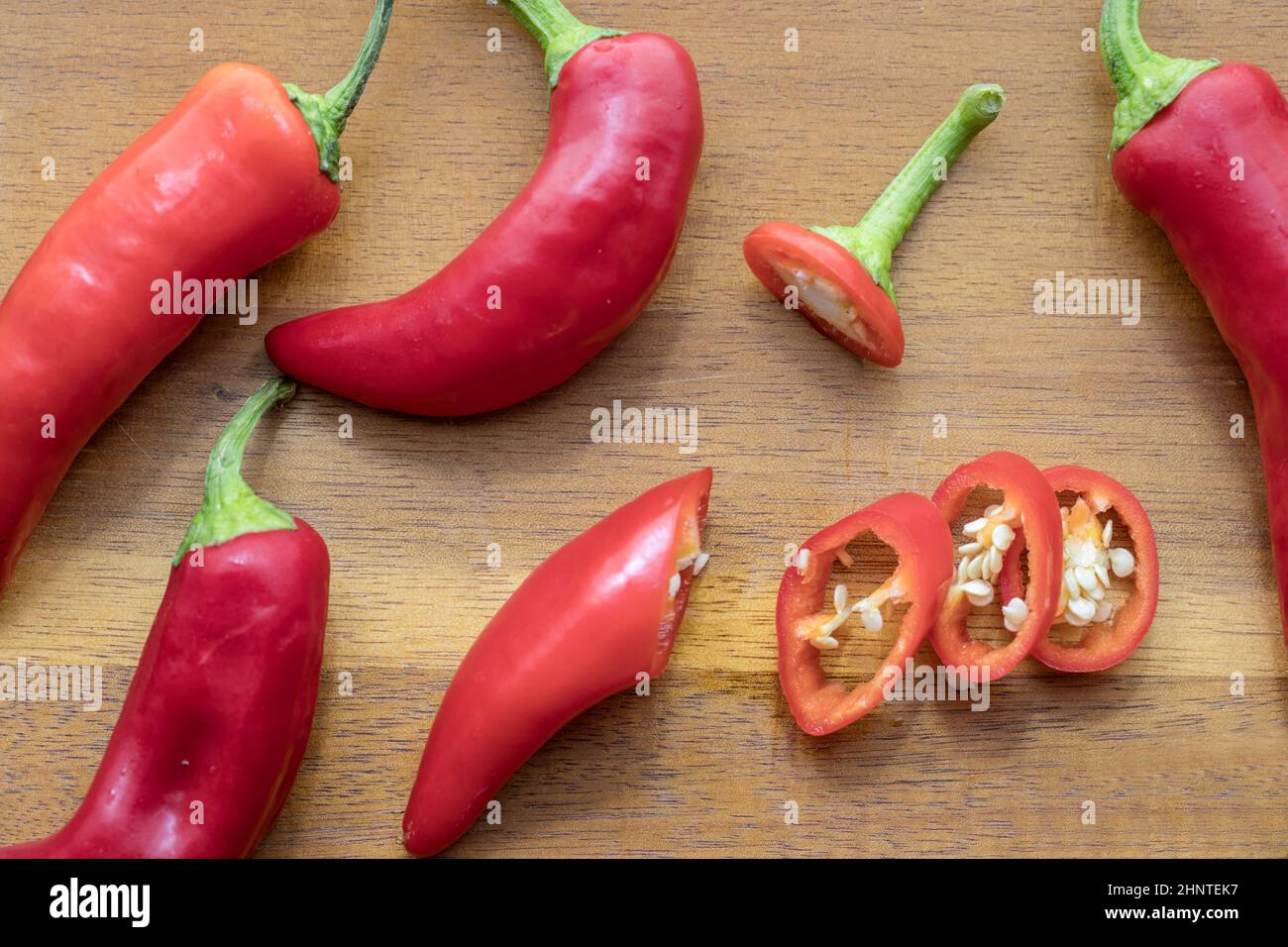 Overhead view of whole and sliced red peppers on a cutting board Stock ...