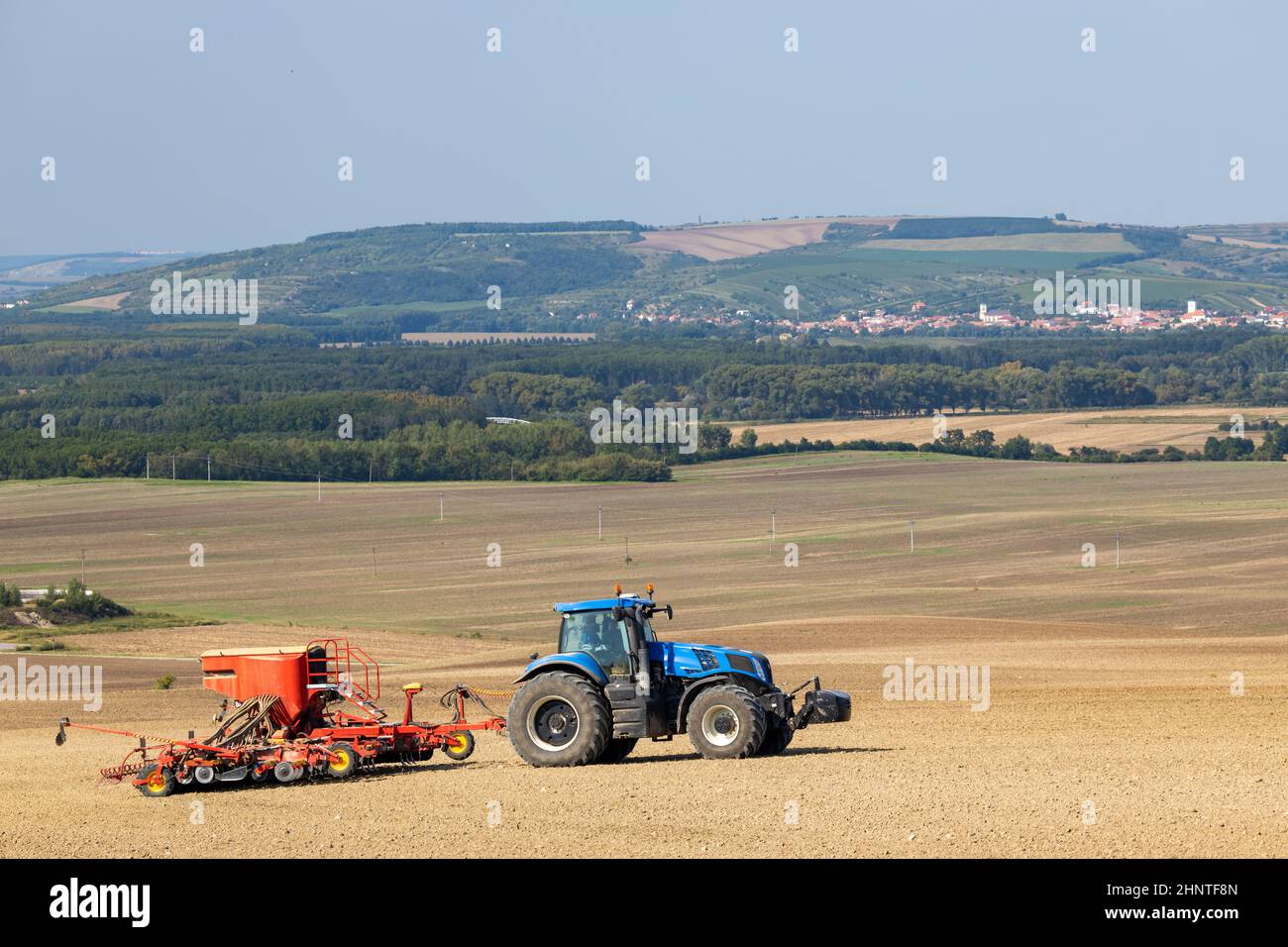 Tractor with seed drill in early spring landscape Stock Photo - Alamy