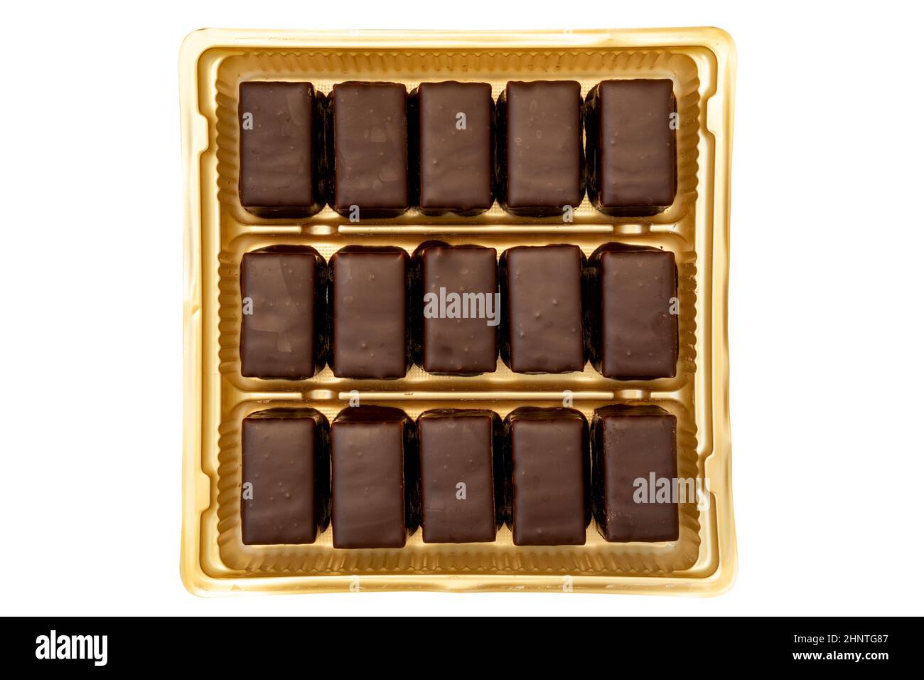 Dark chocolate pralines in a golden square box isolated on white ...