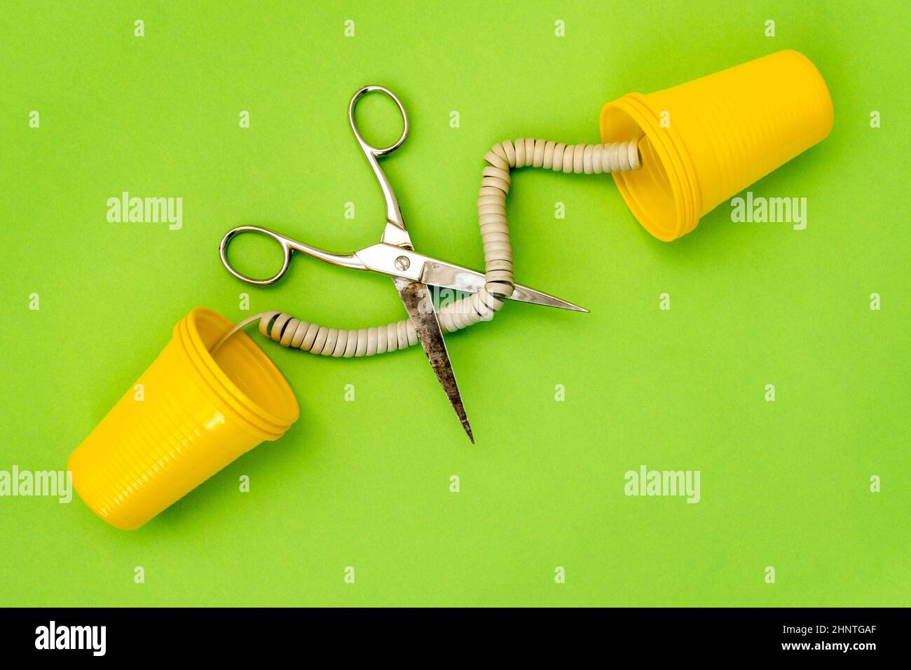 Plastic can phones on green background with the cord got cut off ...