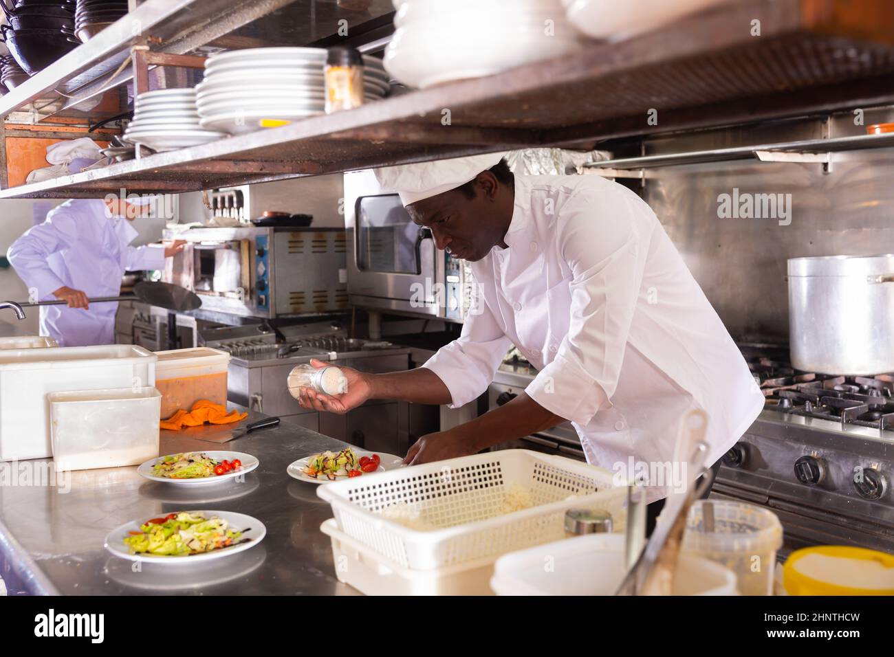 Professional african american cook working in kitchen of restaurant ...