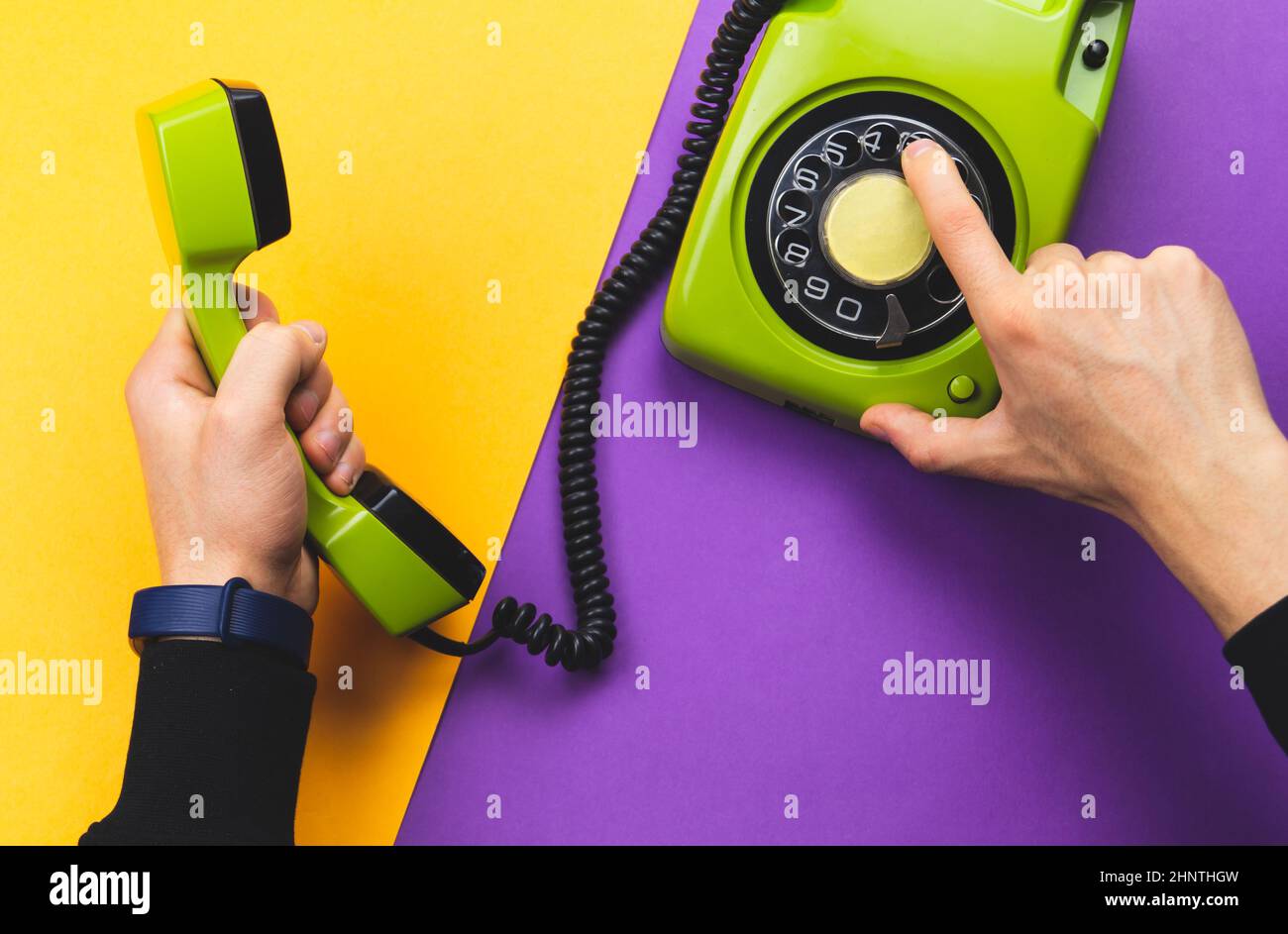 Hand dialing a number on a classic phone with round dial. vintage green ...
