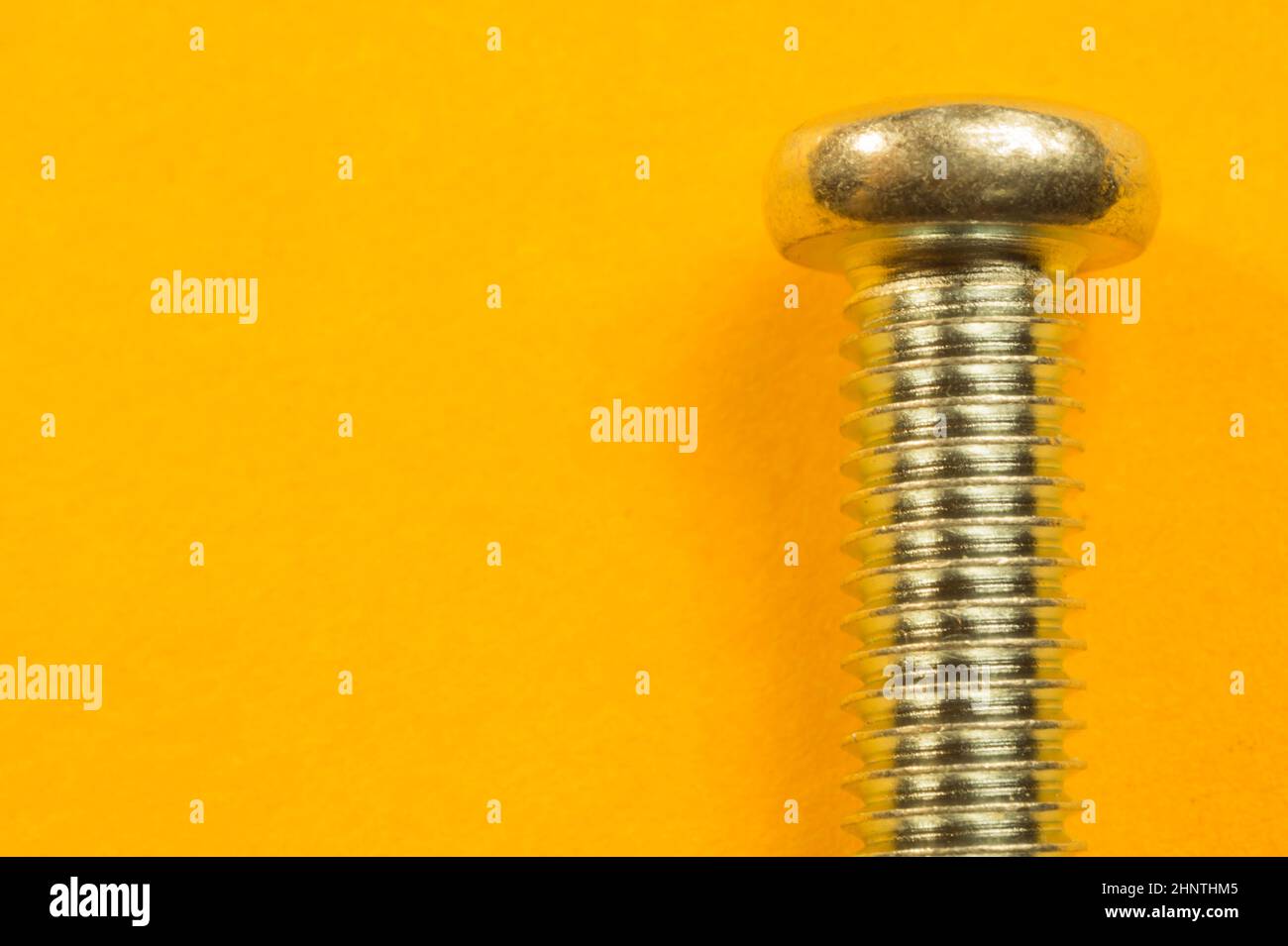 Steel screw on a yellow background. working tools Stock Photo - Alamy