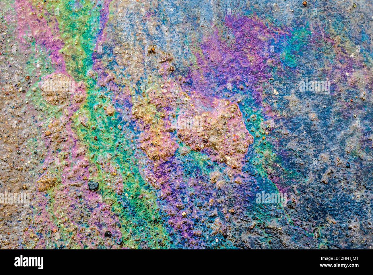 Colorful fuel and oil on an asphalt texture heavy showing enviromental ...