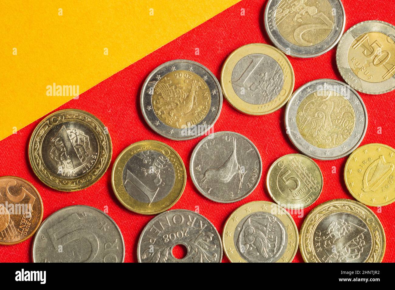 Coins of the different countries on the red background. many metal ...