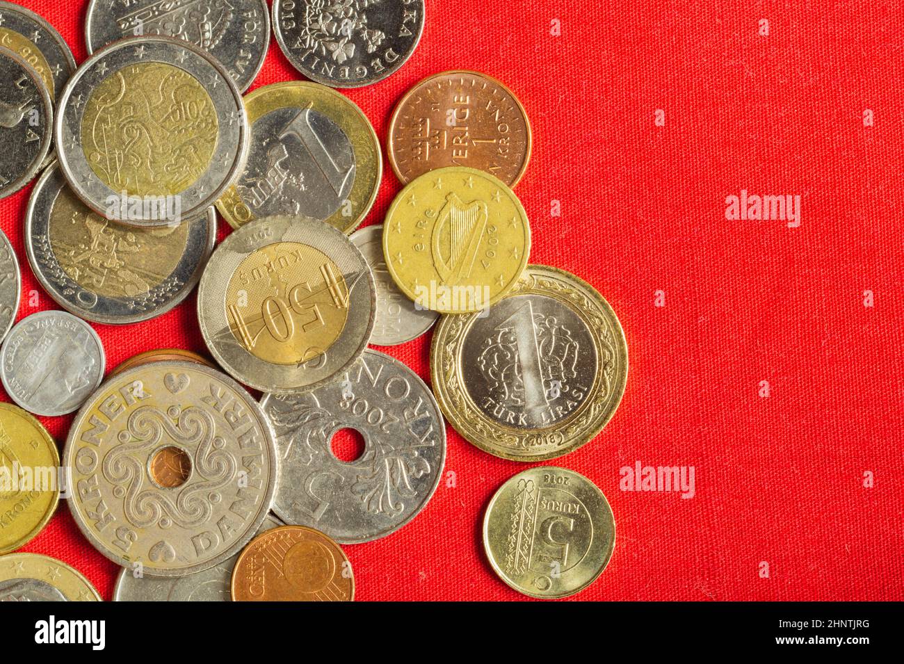 Coins of the different countries on the red background. many metal ...