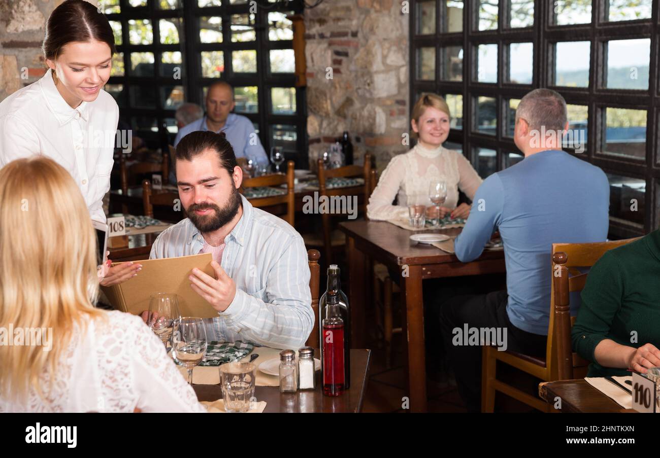 Guests of the country restaurant discuss menu with waitress Stock Photo ...
