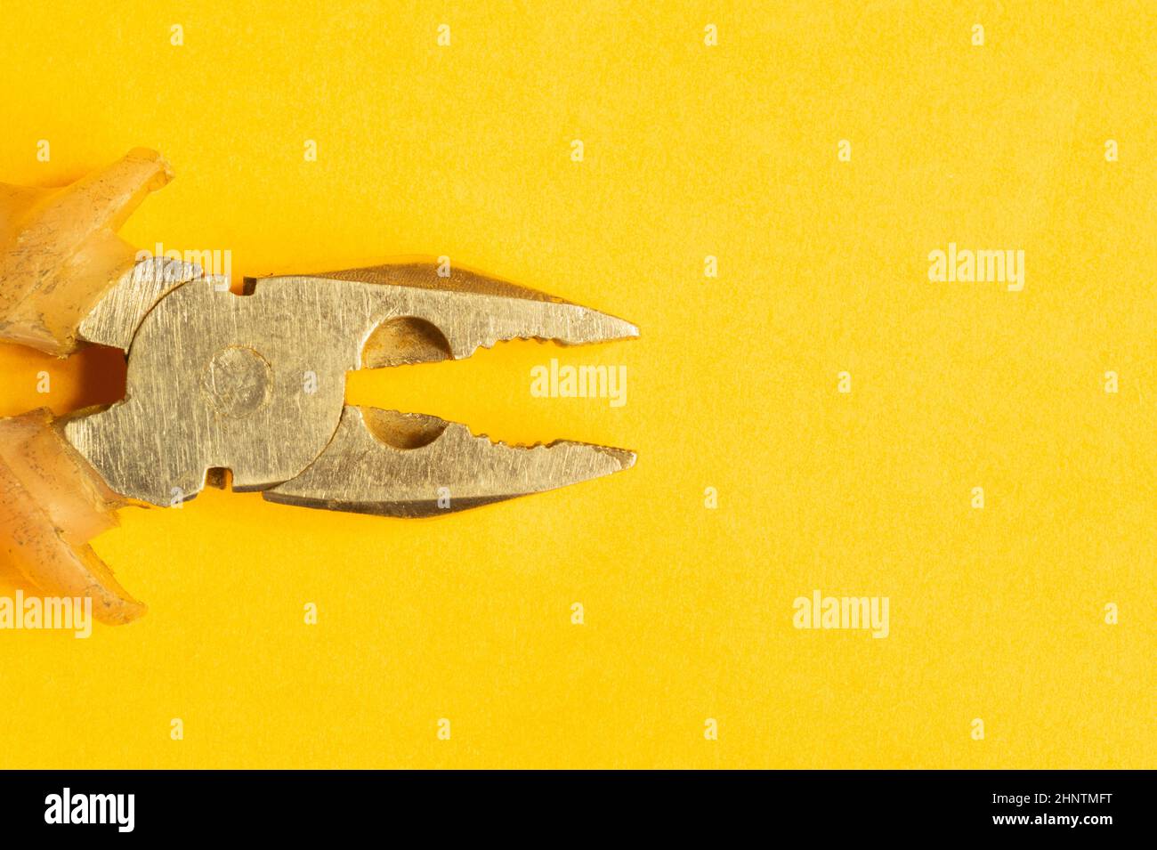 Pliers with orange handles on yellow background. work tool. copy space ...