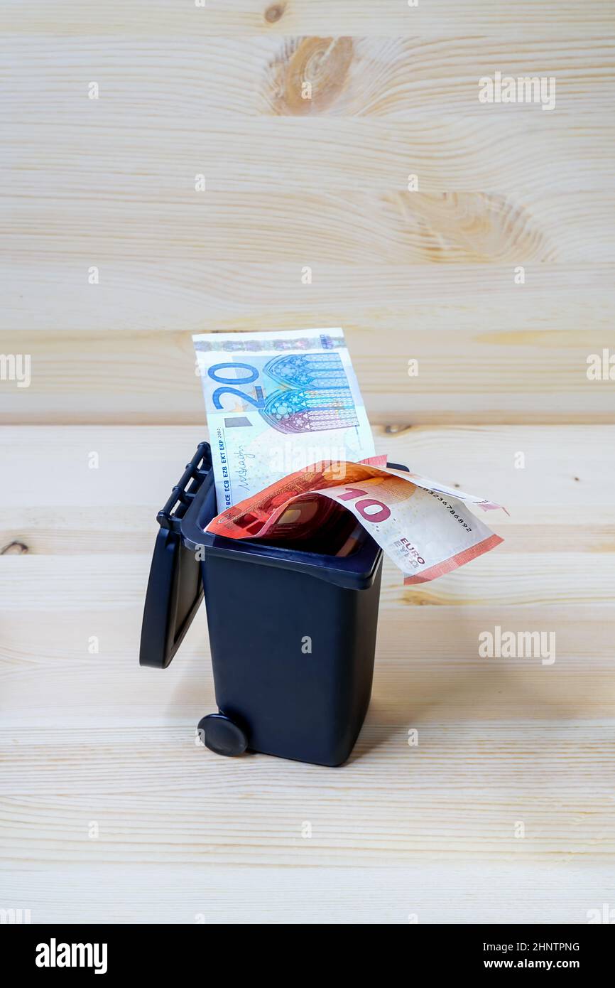 Euro banknote in a garbage can as a symbol for garbage fees, waste of ...