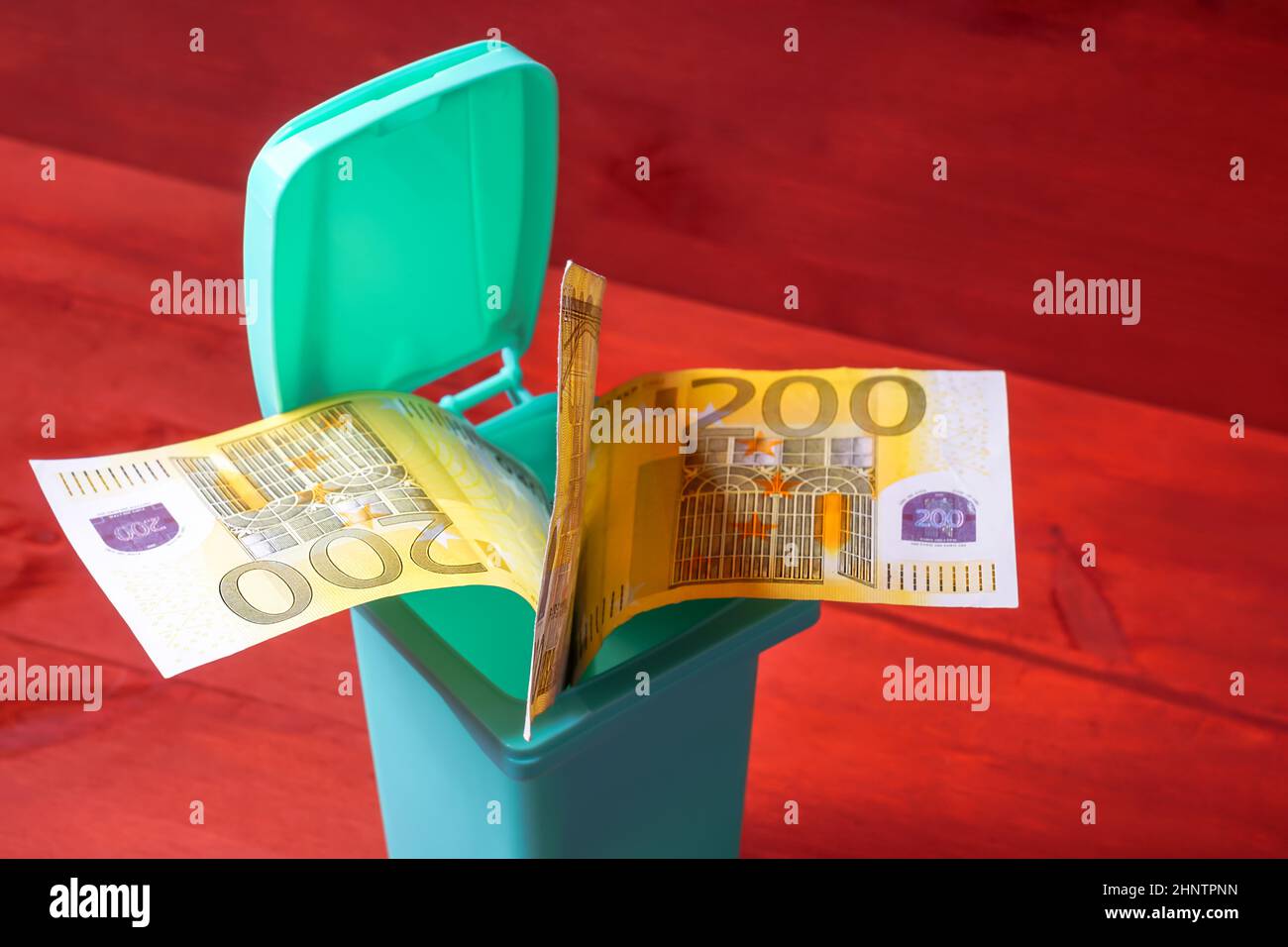 Euro banknote in a garbage can as a symbol for garbage fees, waste of ...