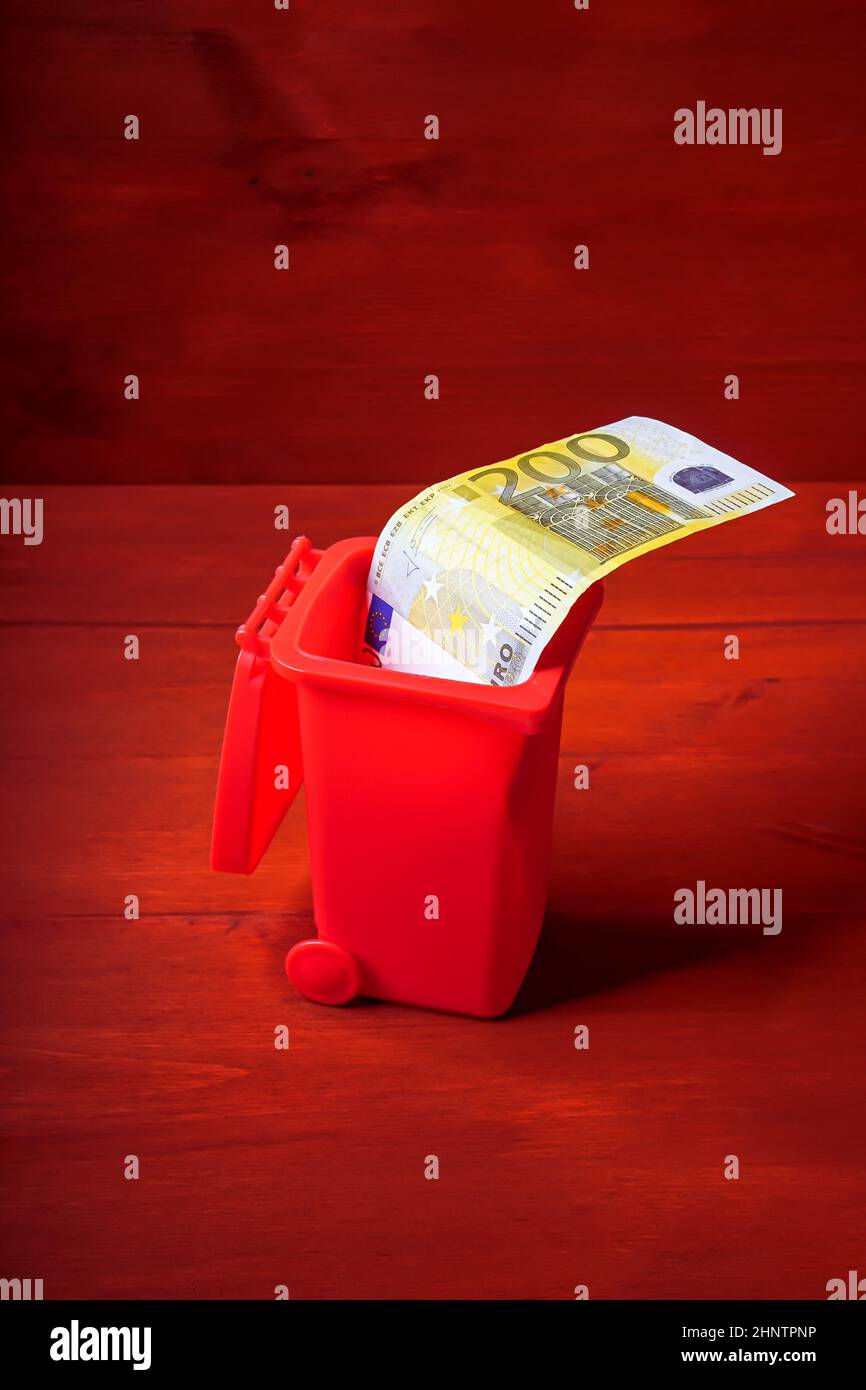 Euro banknote in a garbage can as a symbol for garbage fees, waste of ...