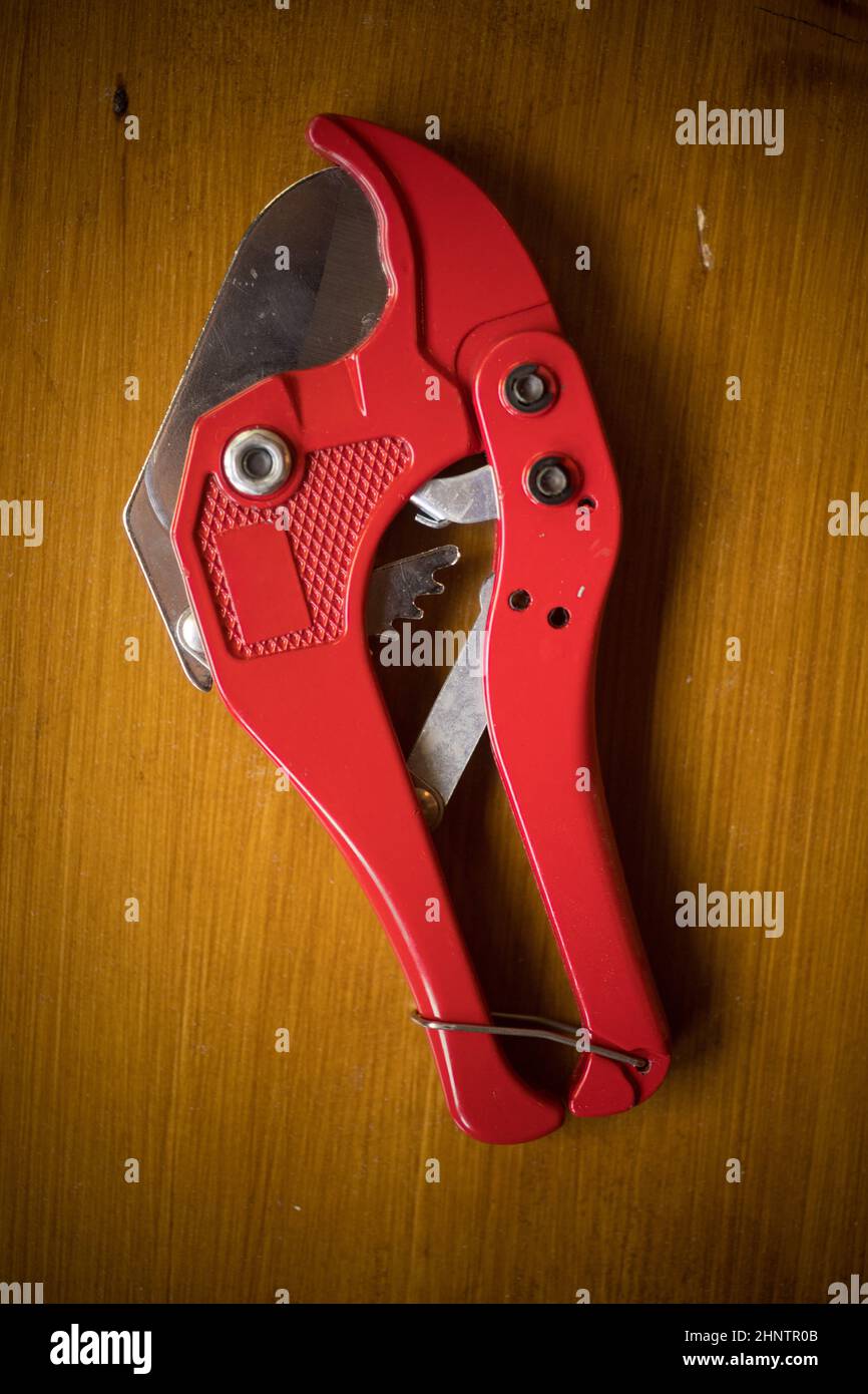 Close up shot of a PVC pipe cutter tool on a wooden background Stock ...
