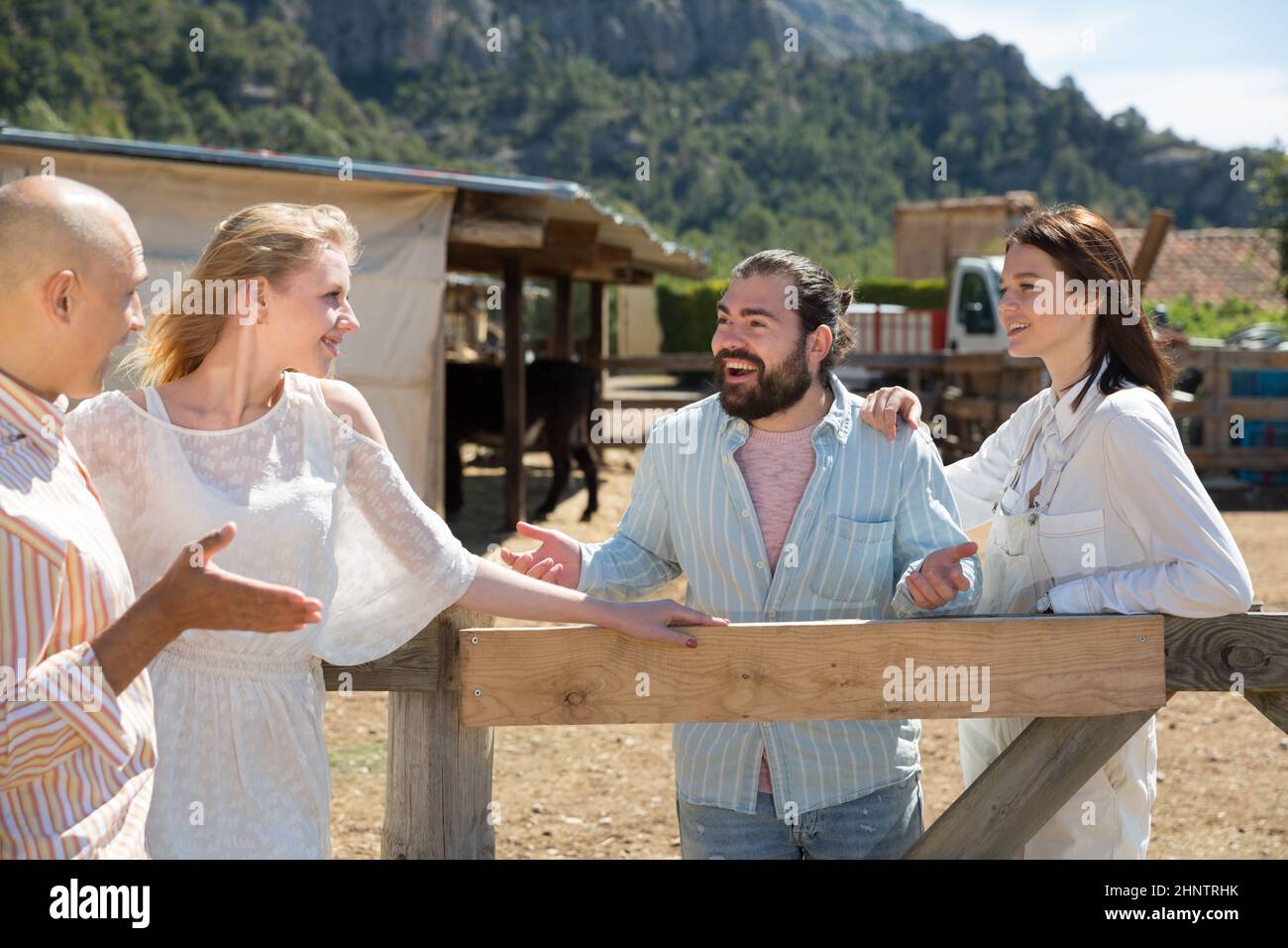 Happy friends chatting on rustic farm background Stock Photo - Alamy
