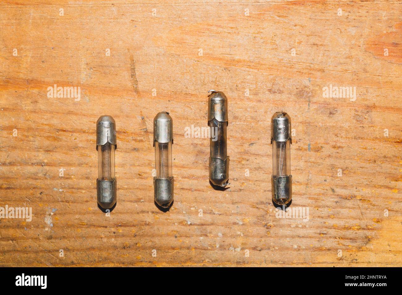 Row of fuses with burned out fuse on wooden background. safety device ...