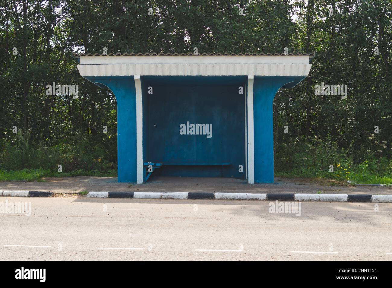 Rural bus stop on the country road with the forest on the background ...