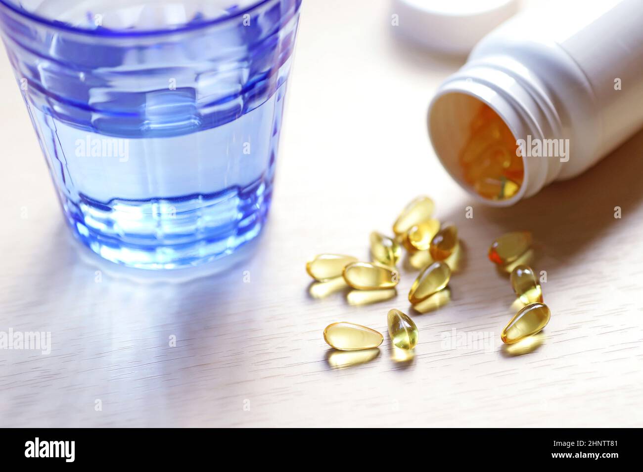 Transparent capsule supplement, plastic container and glass with water ...