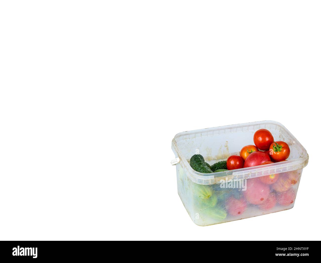 Vegetables, cucumbers and tomatoes in a plastic tray. Green cucumber ...