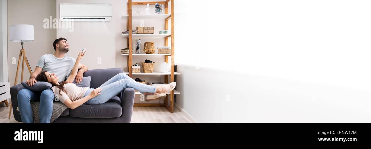 Happy Family Couple Using Air Conditioner. Apartment AC Stock Photo - Alamy