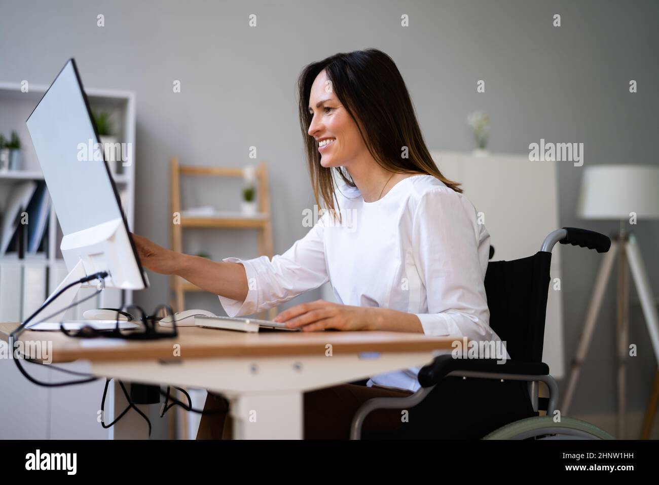Woman With Disabilities In Wheelchair Using Computer Stock Photo - Alamy