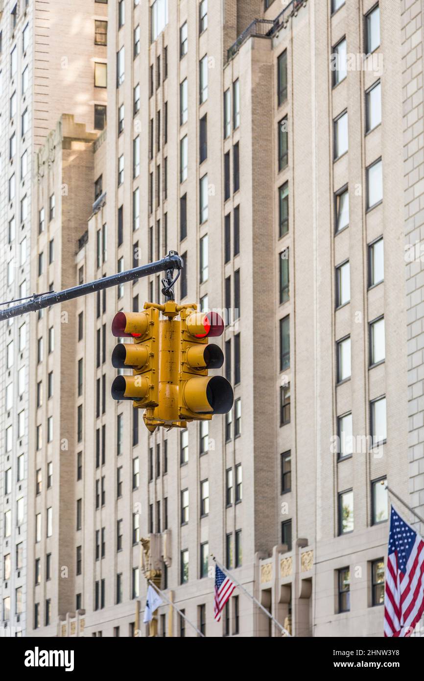 red traffic light in New York with facade of skyscraper in background ...