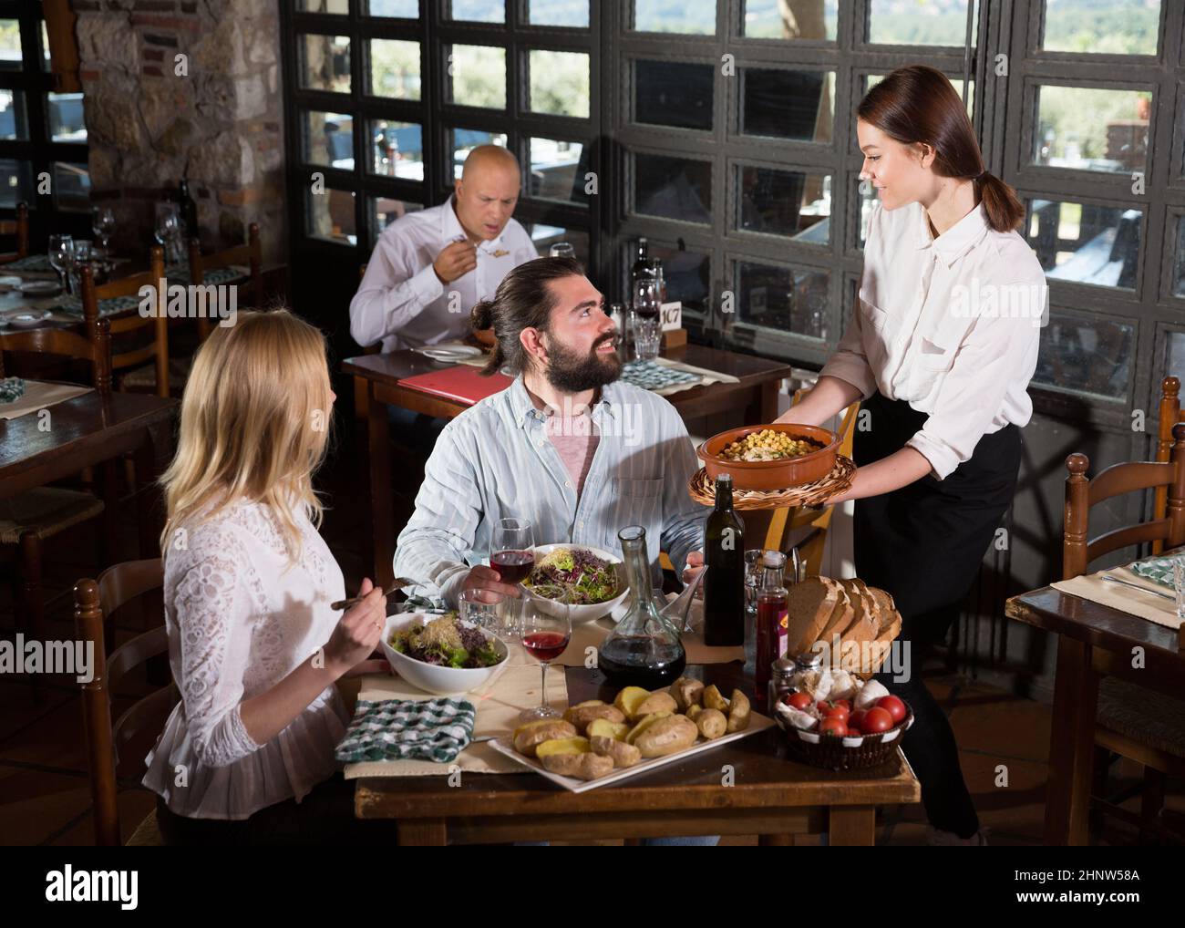 Happy people having dinner at rural restaurant and drinking wine Stock ...
