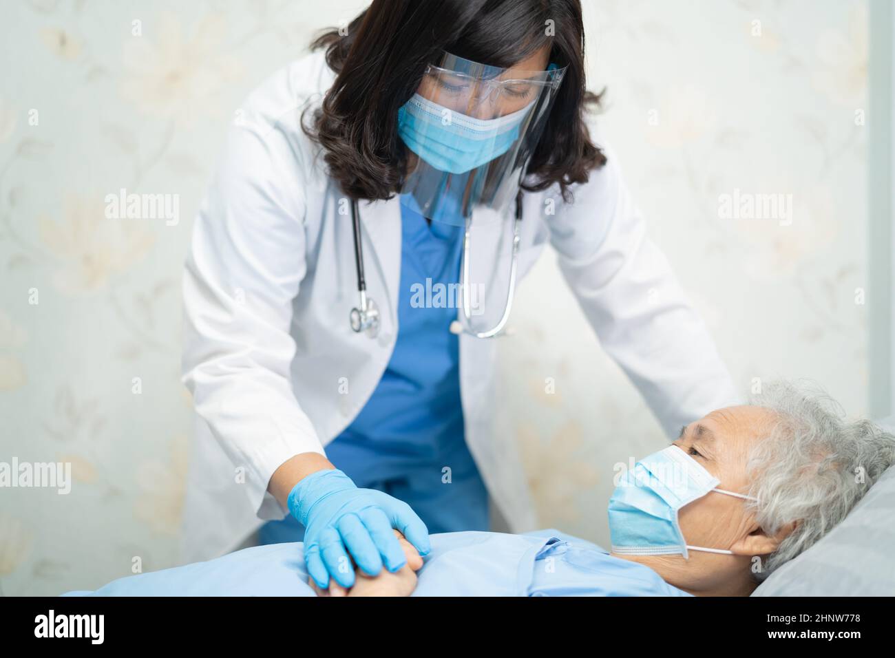 Asian doctor wearing face shield and PPE suit new normal to check ...