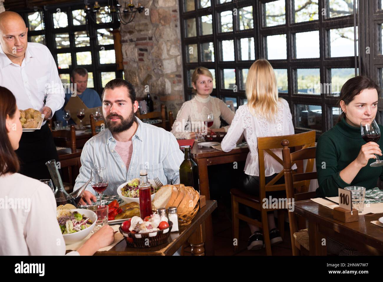 Waiter bringing order to visitors in rural restaurant Stock Photo - Alamy