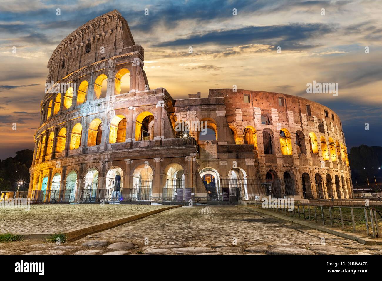 Illuminated Roman Coliseum under the clouds at sunrise, Italy Stock ...