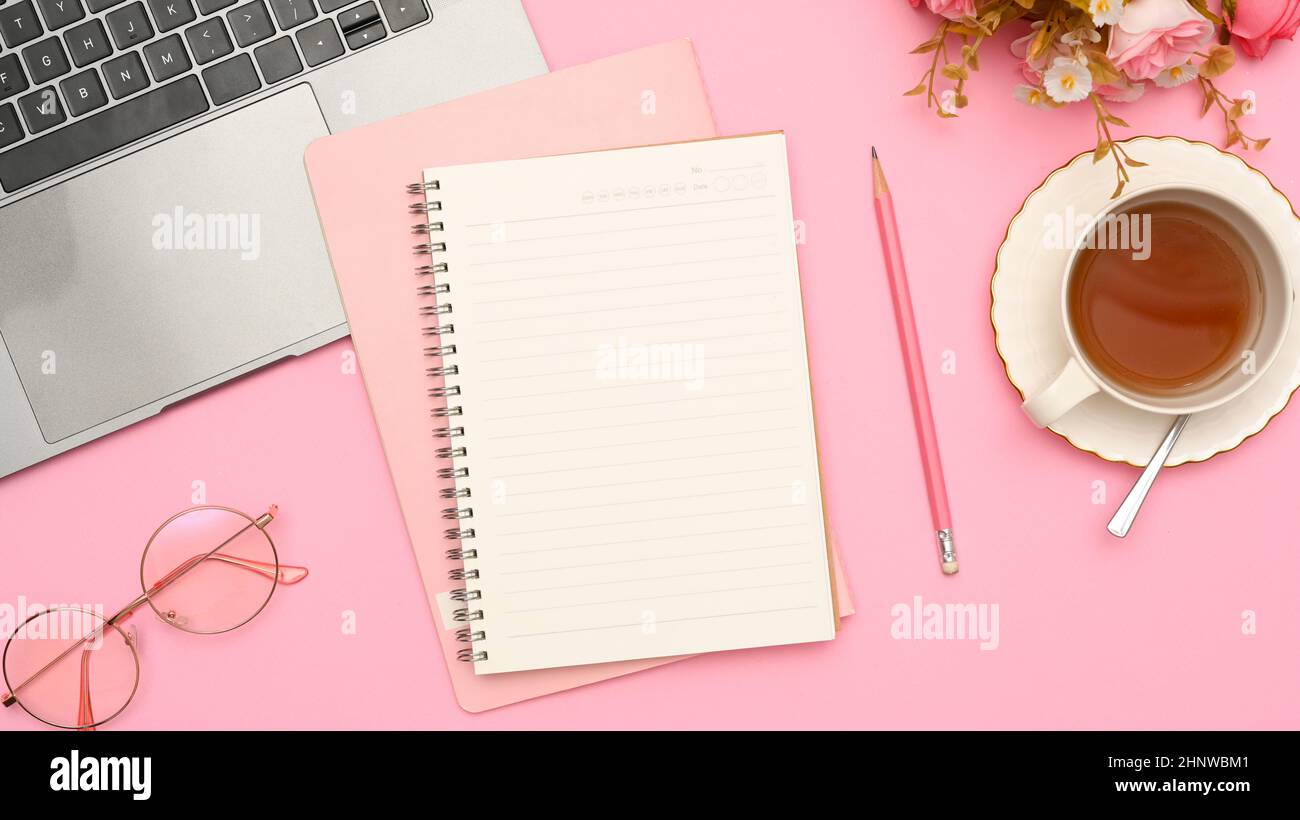 Female teenagers workspace or study table with an empty notebook page ...