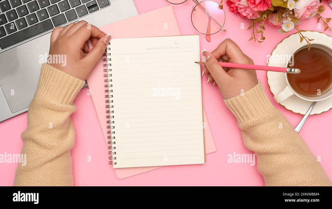Female college student doing homework, writing essay on her school ...