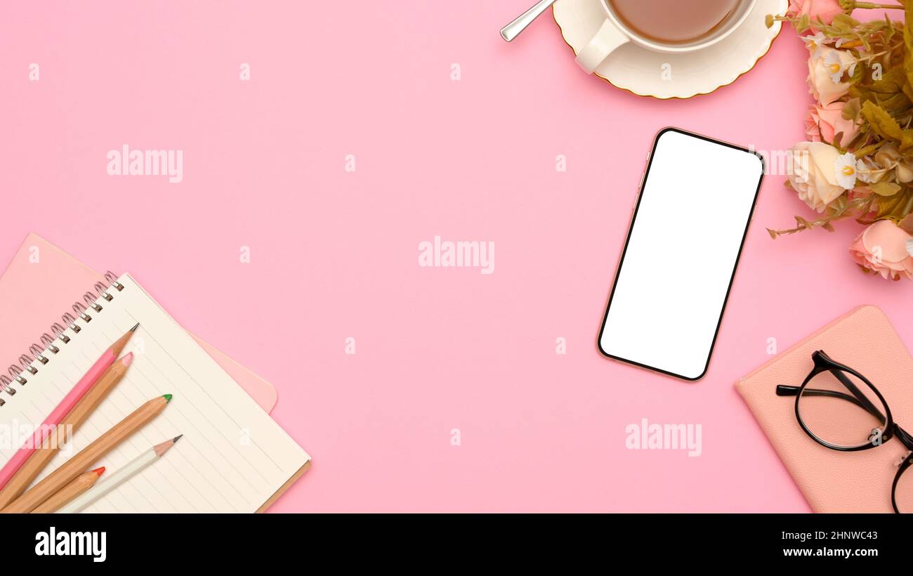 A pink feminine office desk workspace with smartphone white screen ...