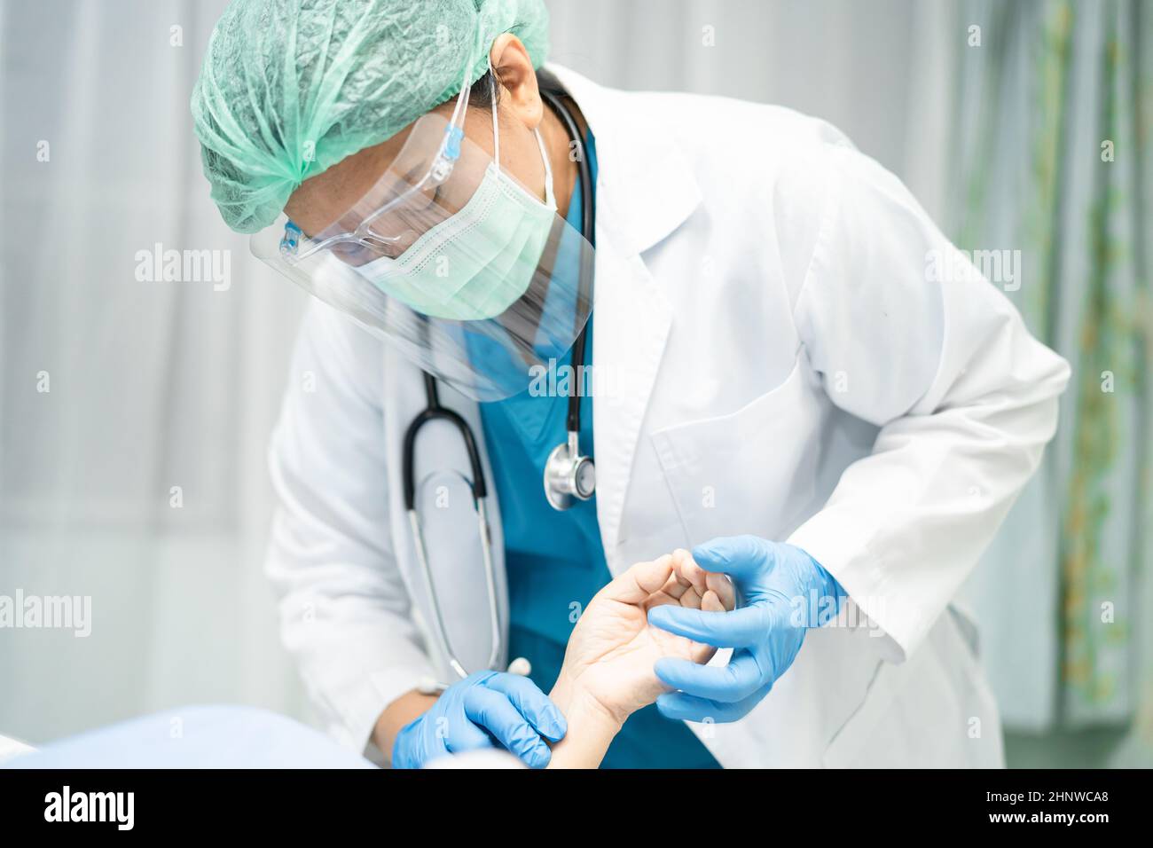 Asian doctor wearing face shield and PPE suit new normal to check ...