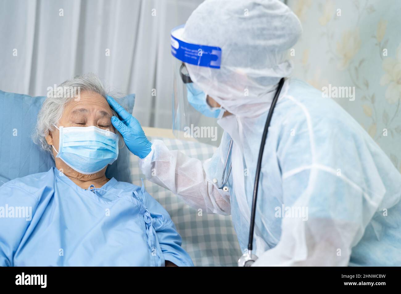 Asian doctor wearing face shield and PPE suit new normal to check ...
