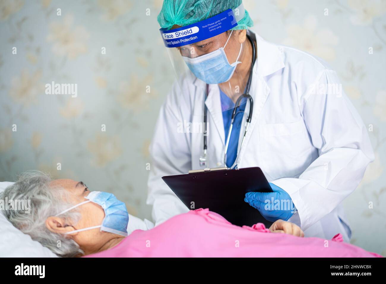 Asian doctor wearing face shield and PPE suit new normal to check ...