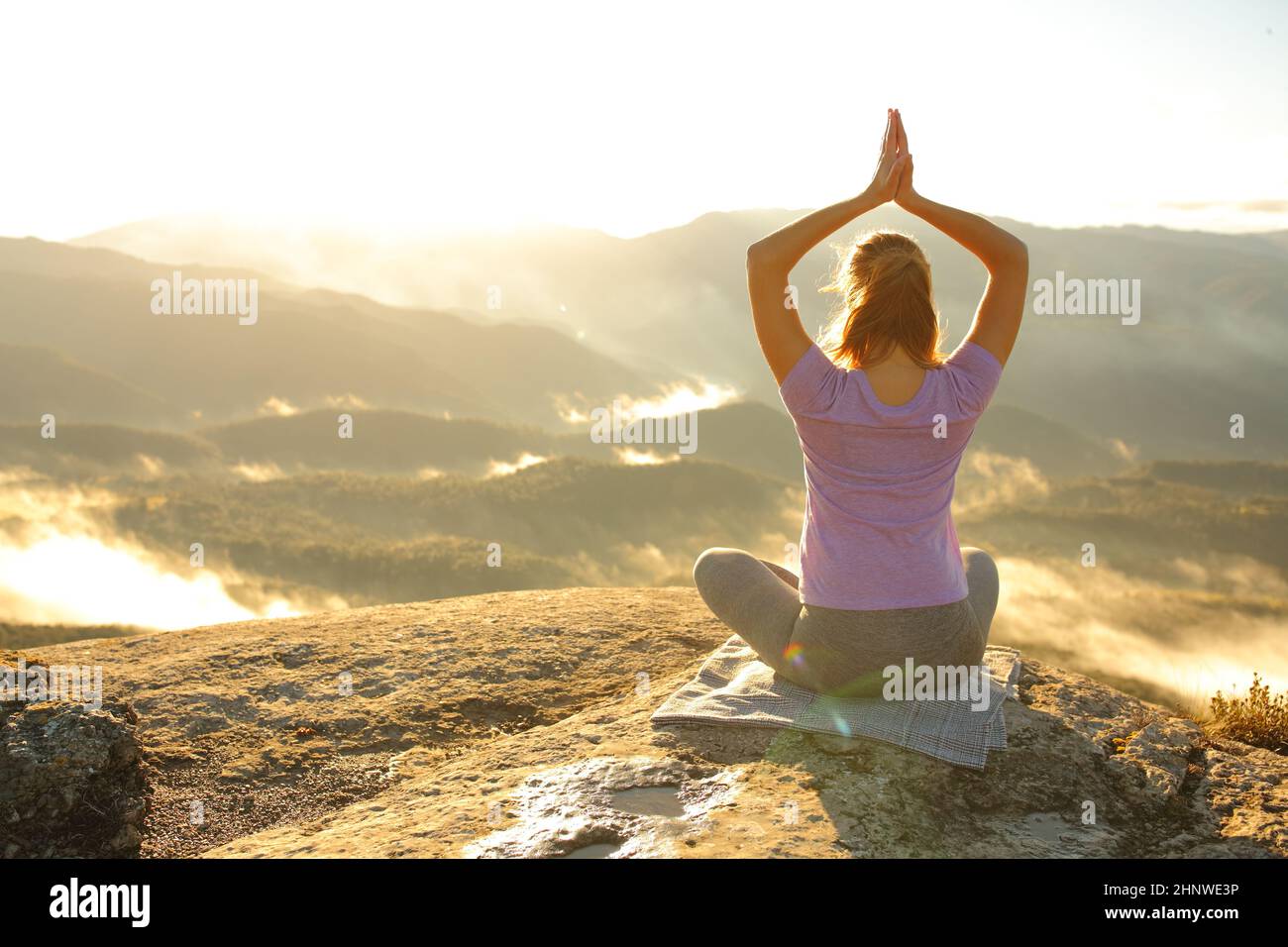 Back view portrait of a woman doing yoga pose in the mountain at ...