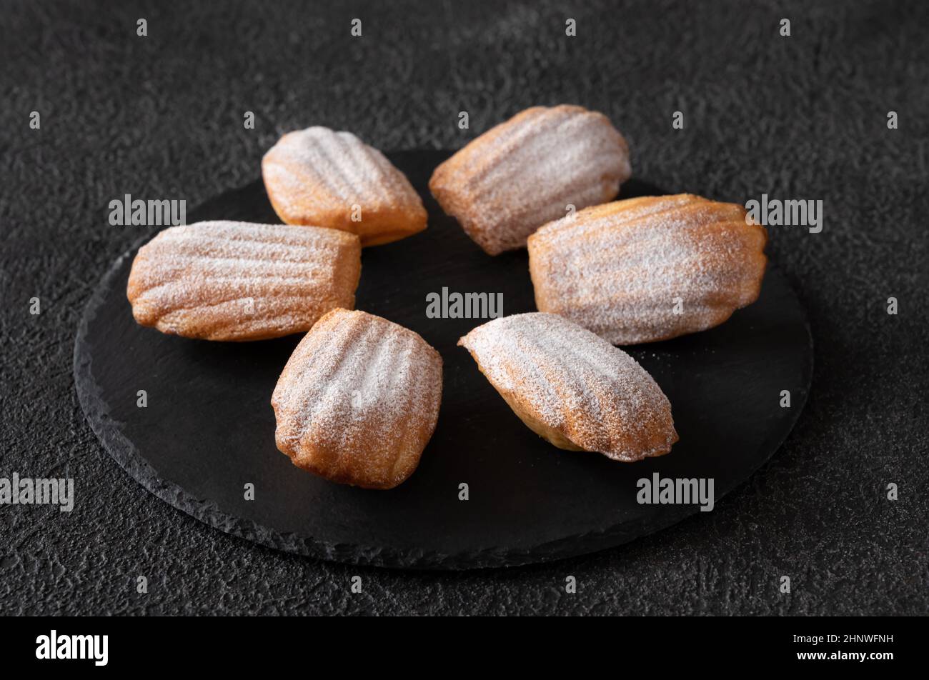 Madeleines - French small sponge cakes on the stone board Stock Photo ...