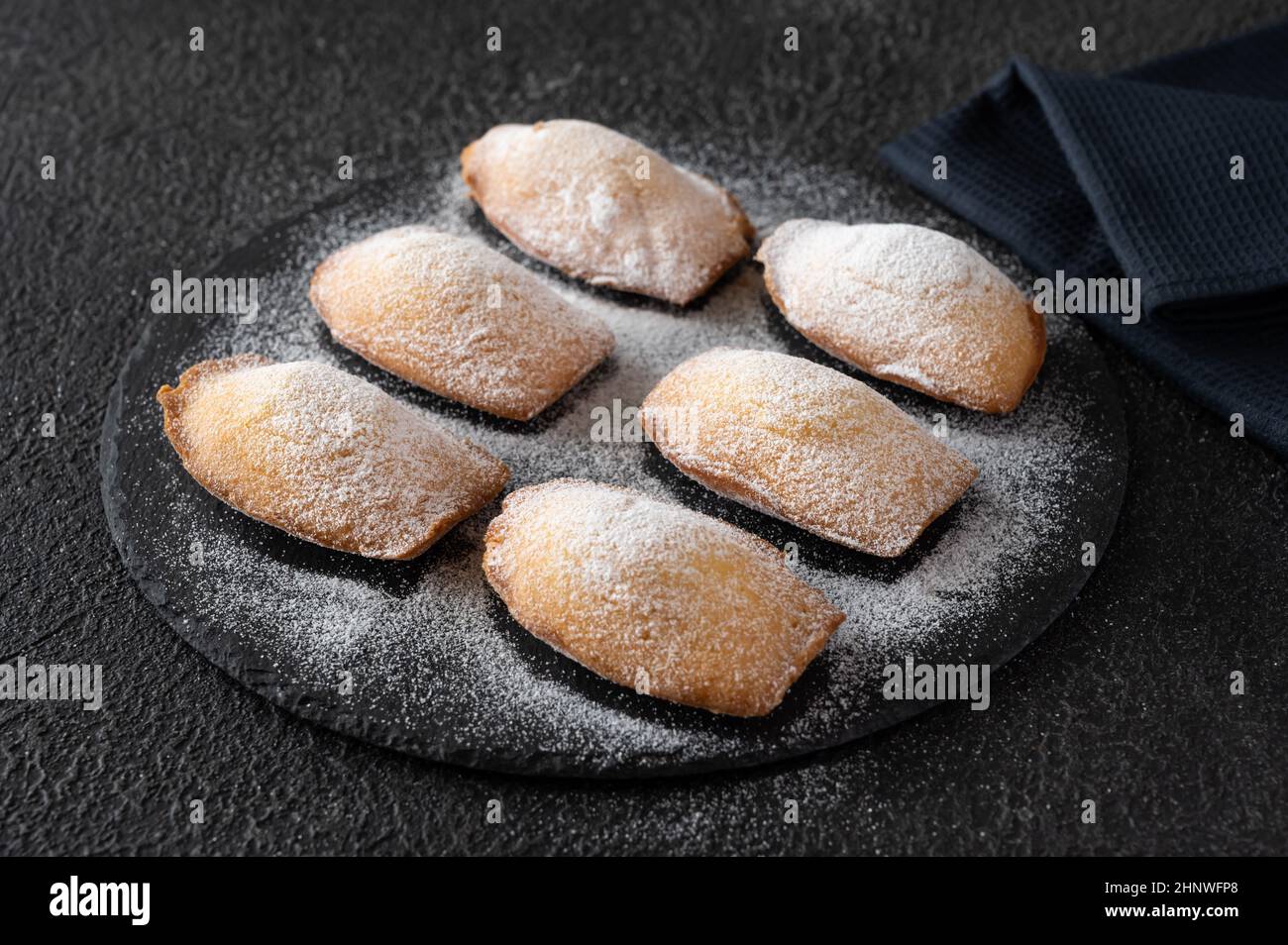 Madeleines - French small sponge cakes on the stone board Stock Photo ...