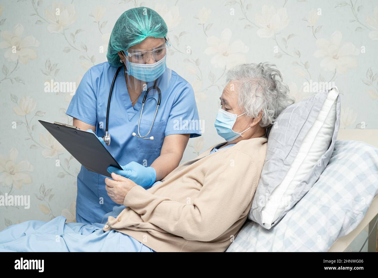 Asian doctor wearing face shield and PPE suit new normal to check ...