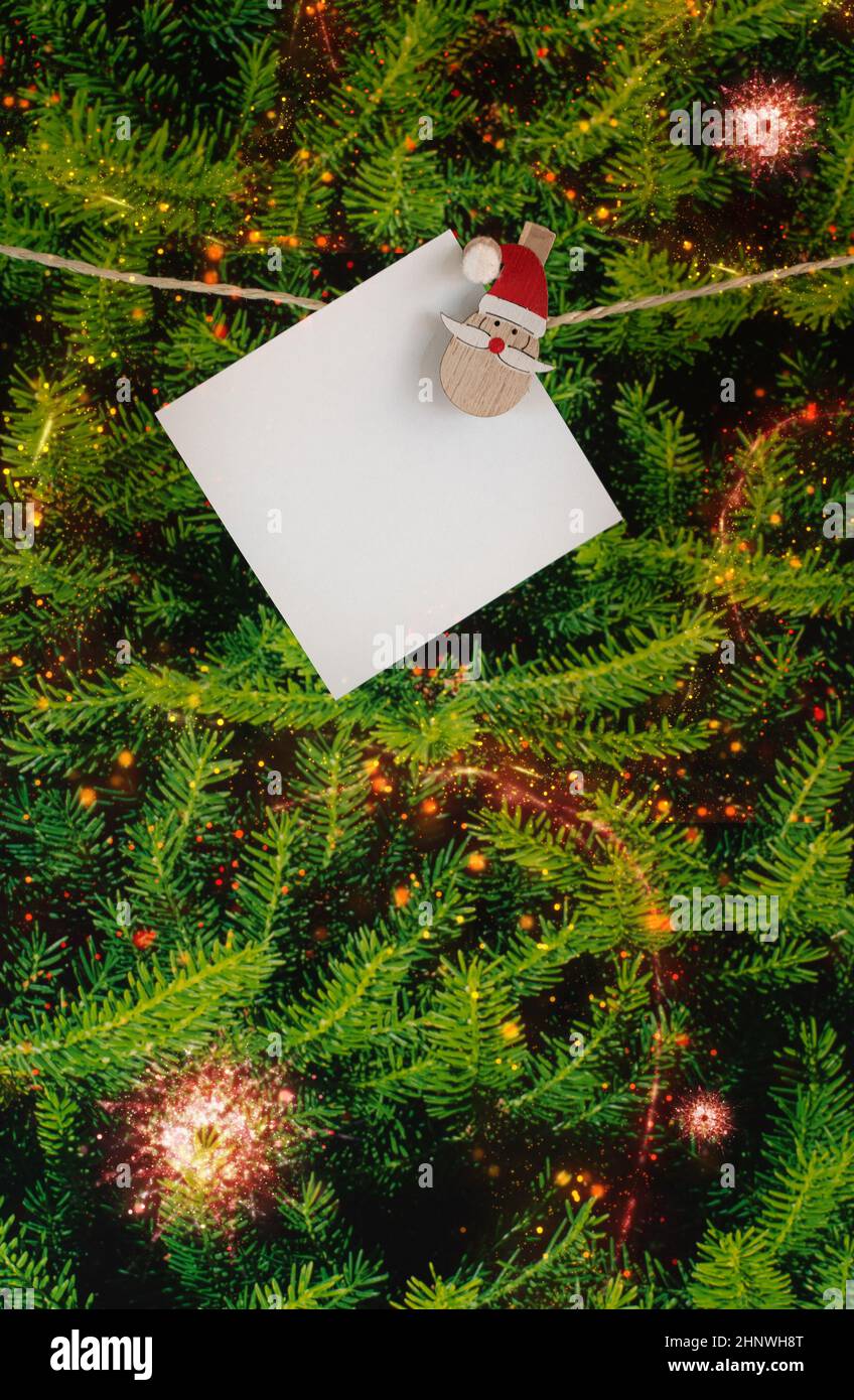 White blank sticky note with a Santa Claus head attached to a cord, in ...