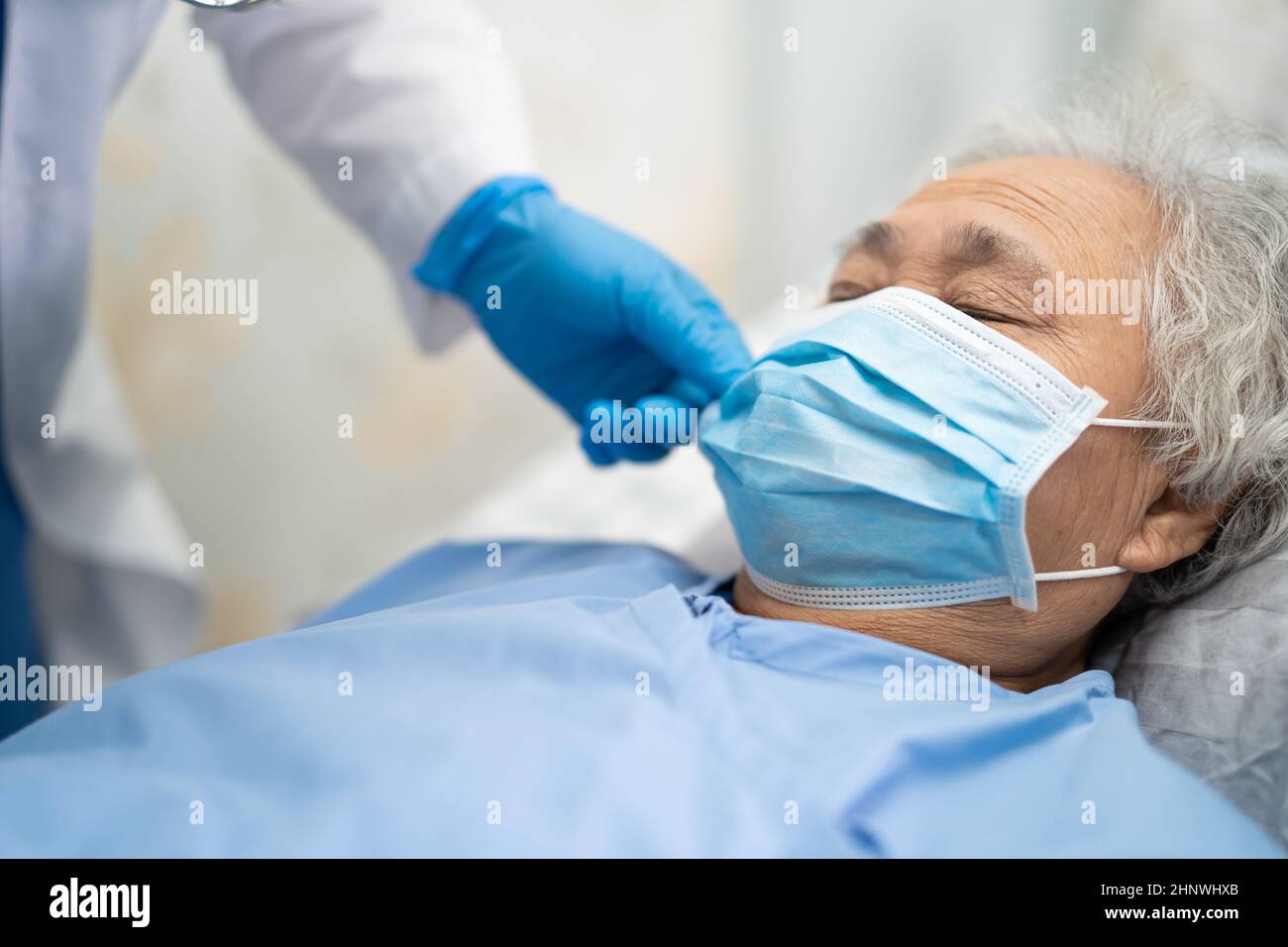 Asian doctor wearing PPE suit and glove new normal to check patient ...