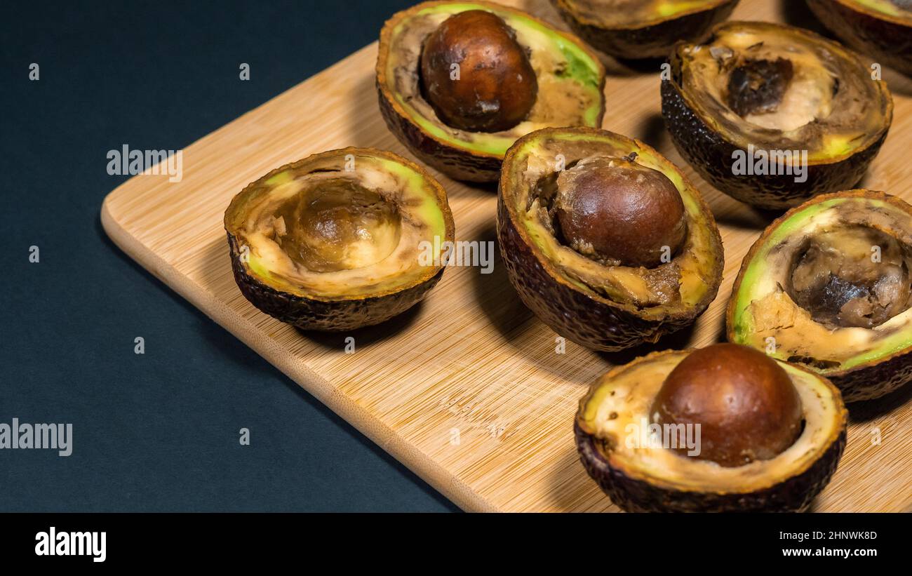 Rotten Avocados Halfs on table. Bad Fruits on wood Chipper. Overripe ...