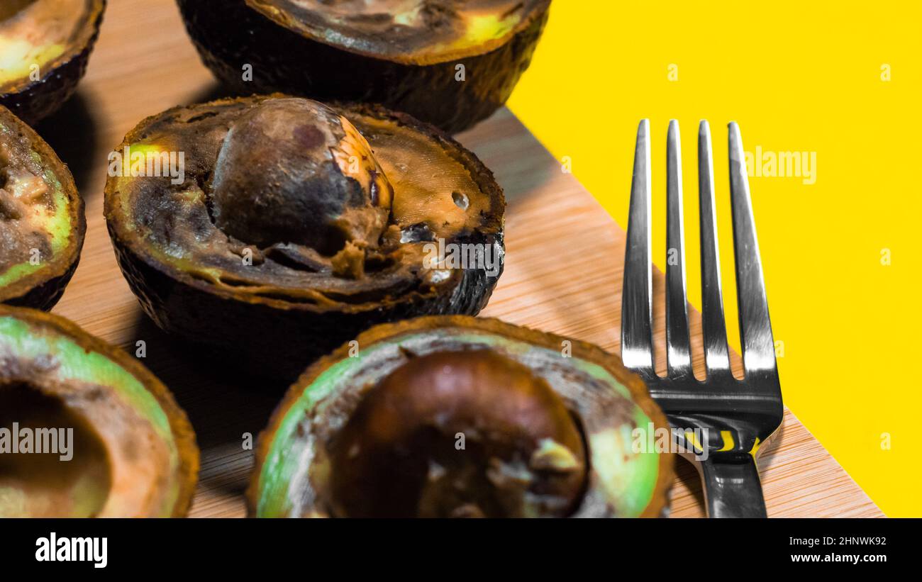 Contaminated tropical fruits. Bad Avocado Half Close up on Yellow ...