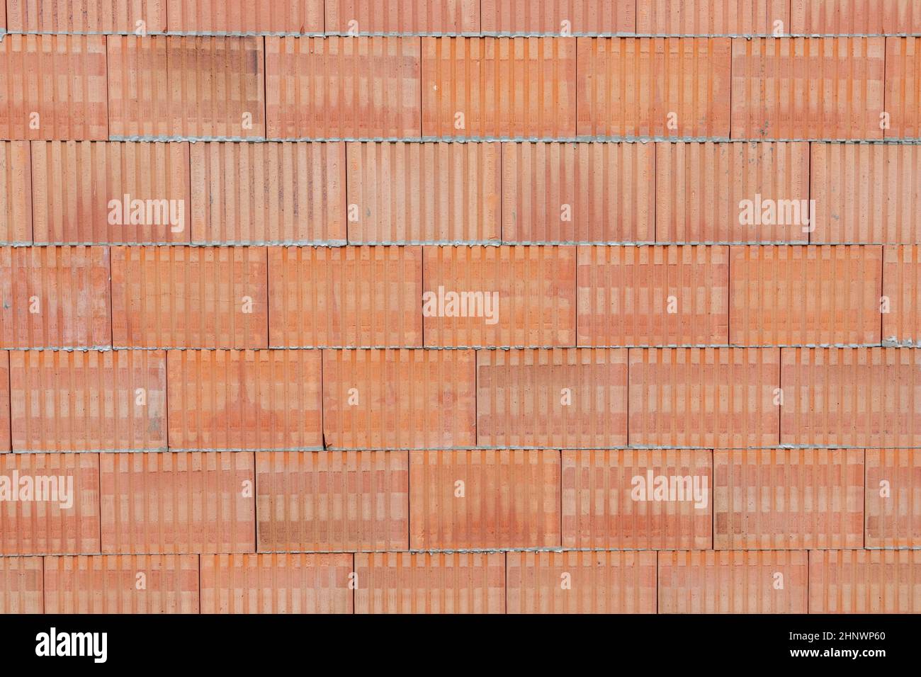 solid red brick wall of a house under construction as background Stock ...