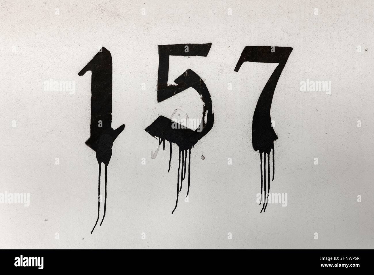 number 157 painted in old letter with flowing dried black paint at a ...