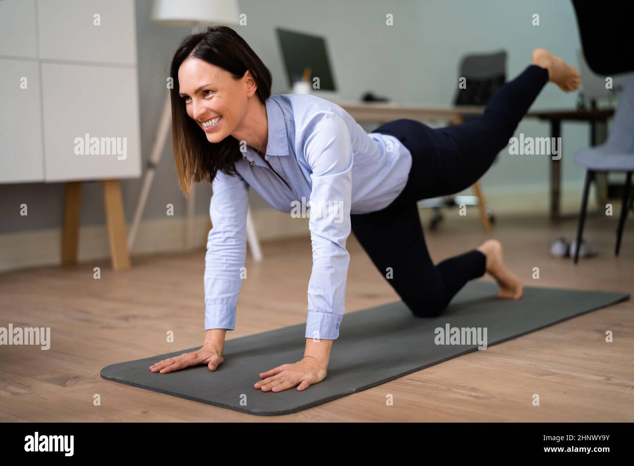 Yoga Leg Workout In Office Near Desk And Computer Stock Photo - Alamy